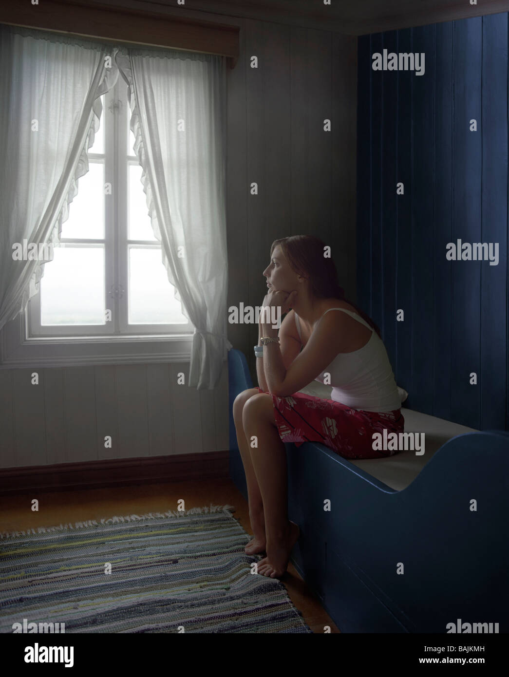 Sad Woman Sitting Alone in Room, daydreaming, side view Stock Photo - Alamy