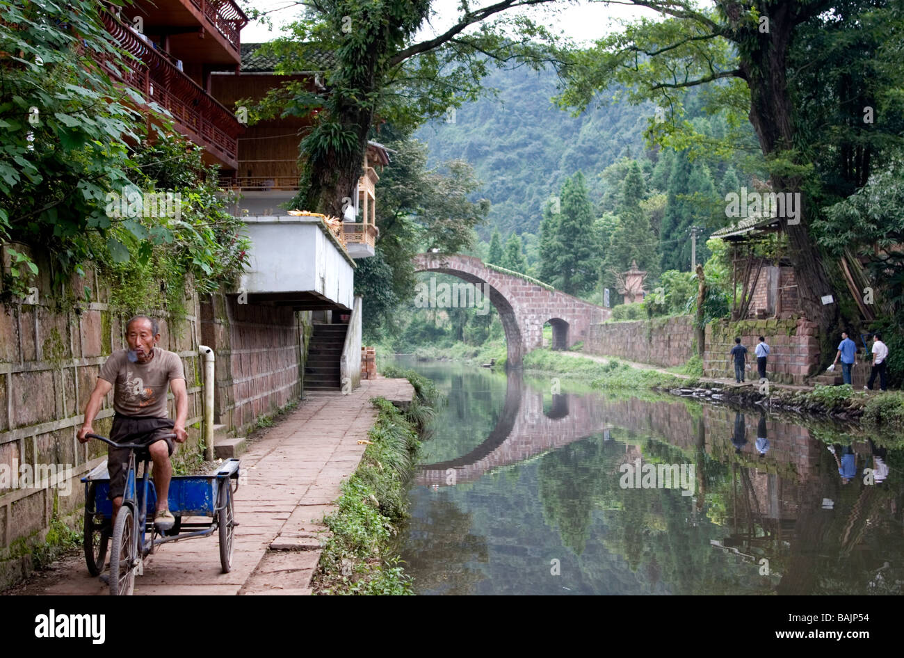 An old arched stone bridge over the stream in the old village of ...