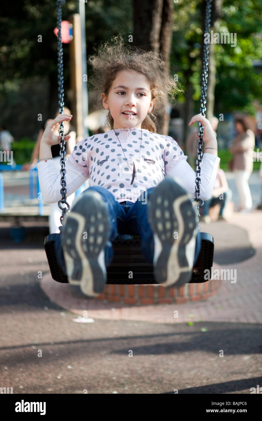 Child on a swing at the playground Stock Photo - Alamy