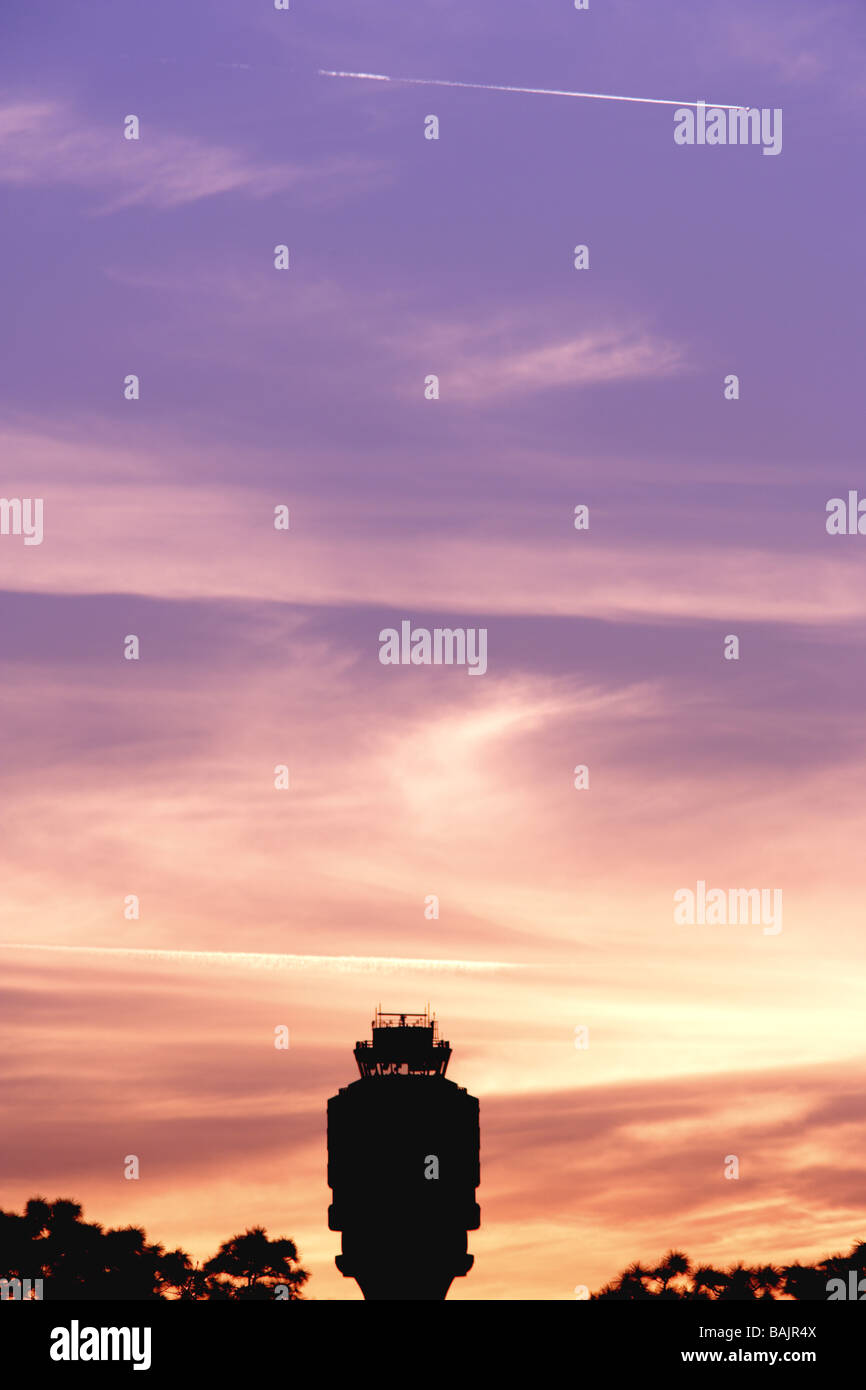 Airport control tower with airplane overhead at altitude Stock Photo ...
