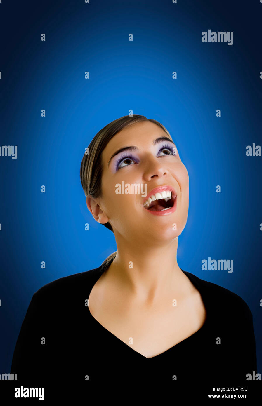 Beautiful woman portrait looking to the top on a blue background Stock ...