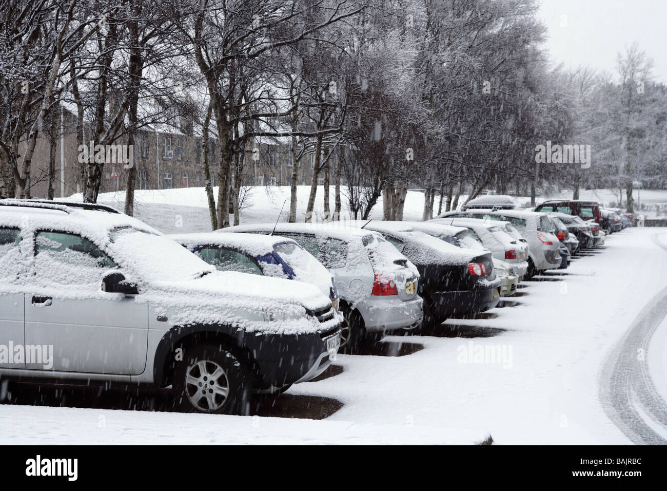 Snow falling and settling on cars parked in a car park Stock Photo - Alamy