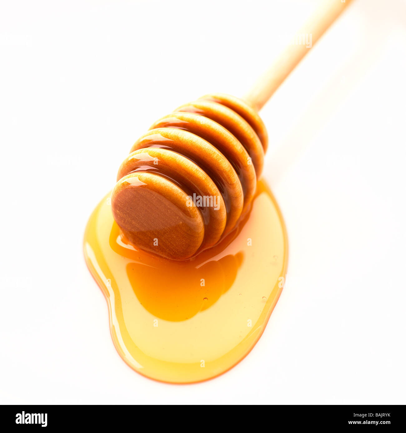 Dipper in pool of honey on white back ground Stock Photo - Alamy