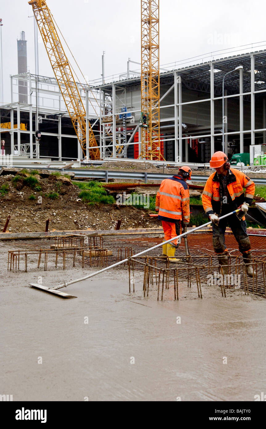 Construction worker evens out a layer of fresh concrete Stock Photo - Alamy