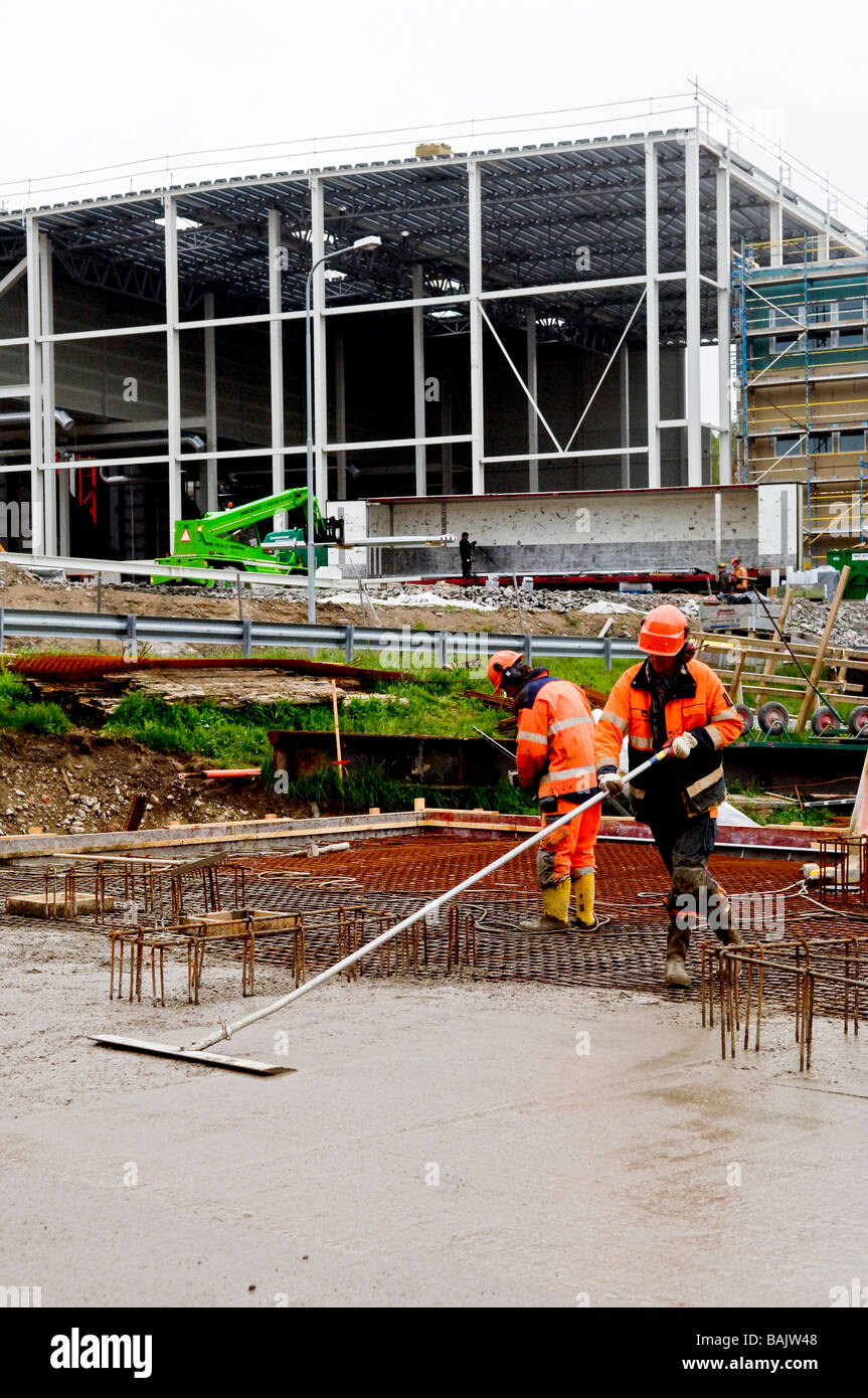 Construction worker evens out a layer of fresh concrete Stock Photo - Alamy