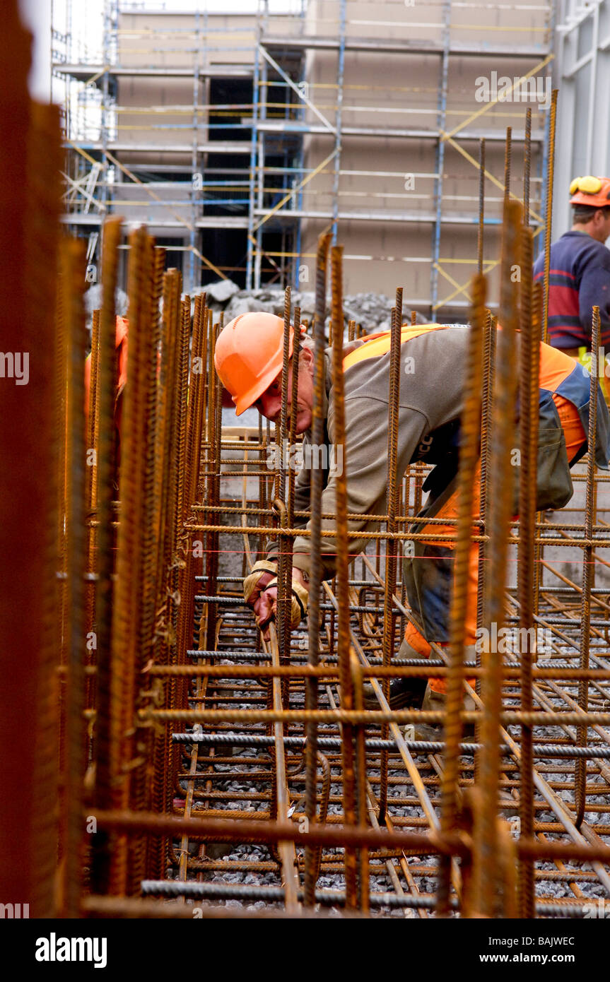 Construction workers putting reinforcement rods together before pouring ...