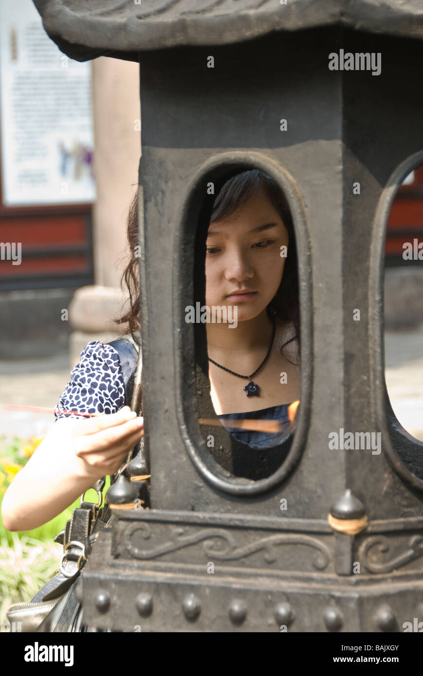 Young Chinese woman lighting incense at the Wenshu Temple in Chengdu, Sichuan, China Stock Photo ...