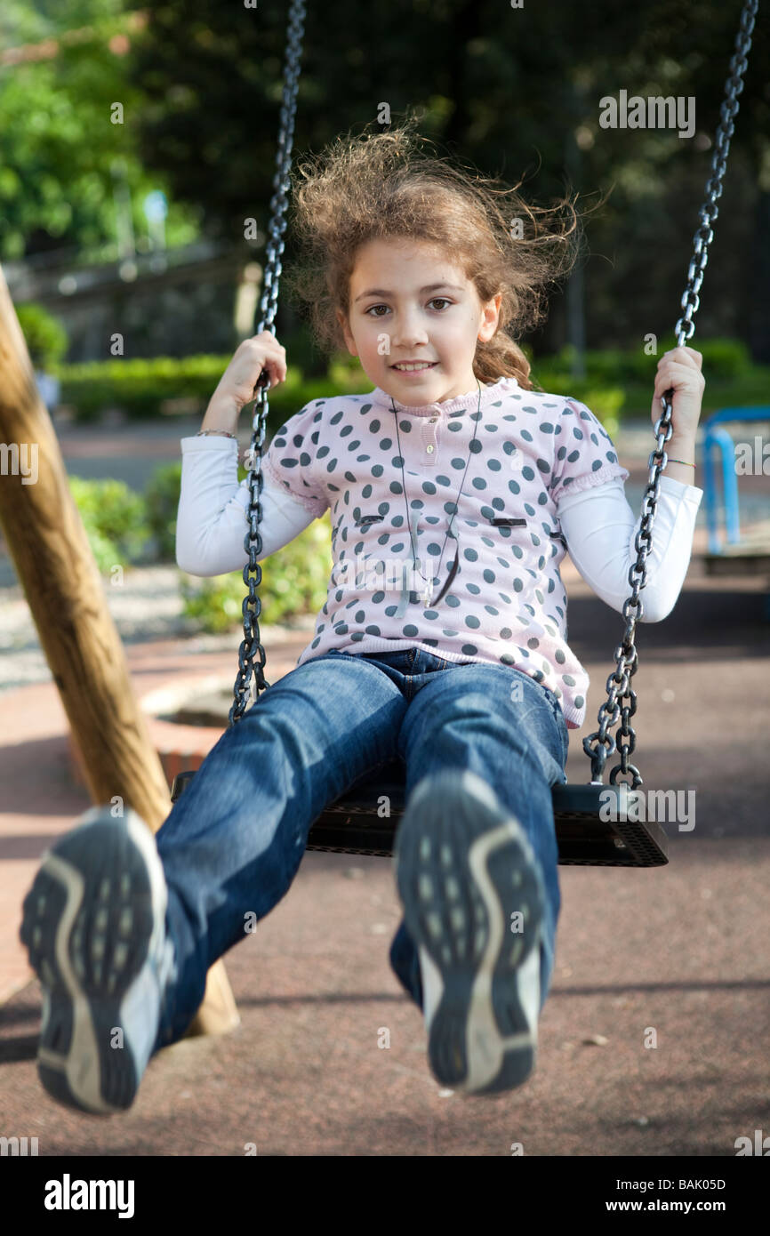 Child on a swing at the playground Stock Photo - Alamy