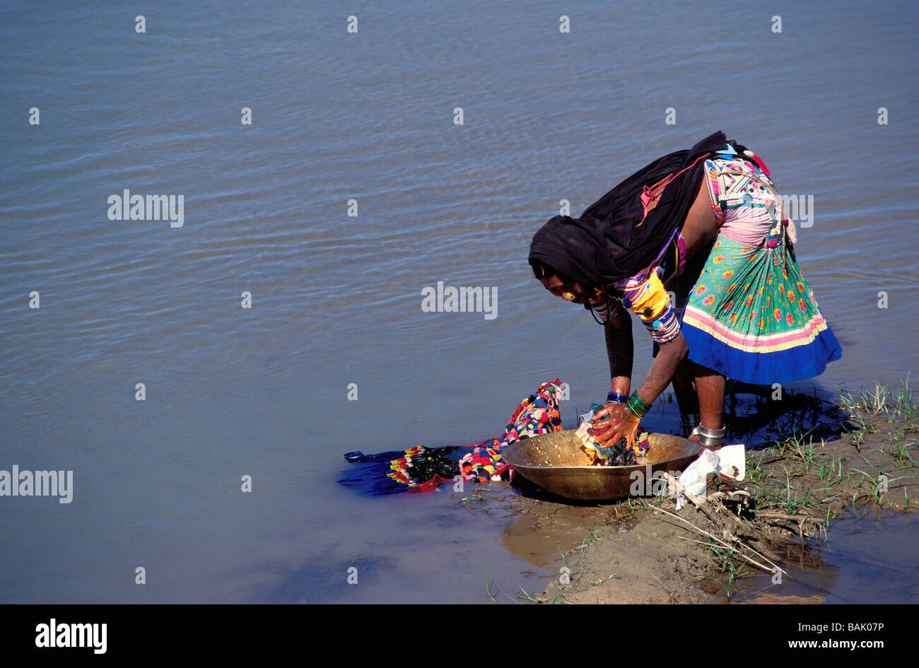 Nepal, Terai Region (Madhesh), Rana Tharu ethnic group, woman washing ...
