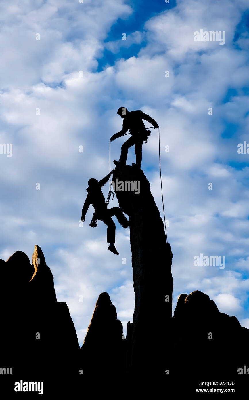 Team of climbers reaching the summit of a rock pinnacle in The Sierra ...