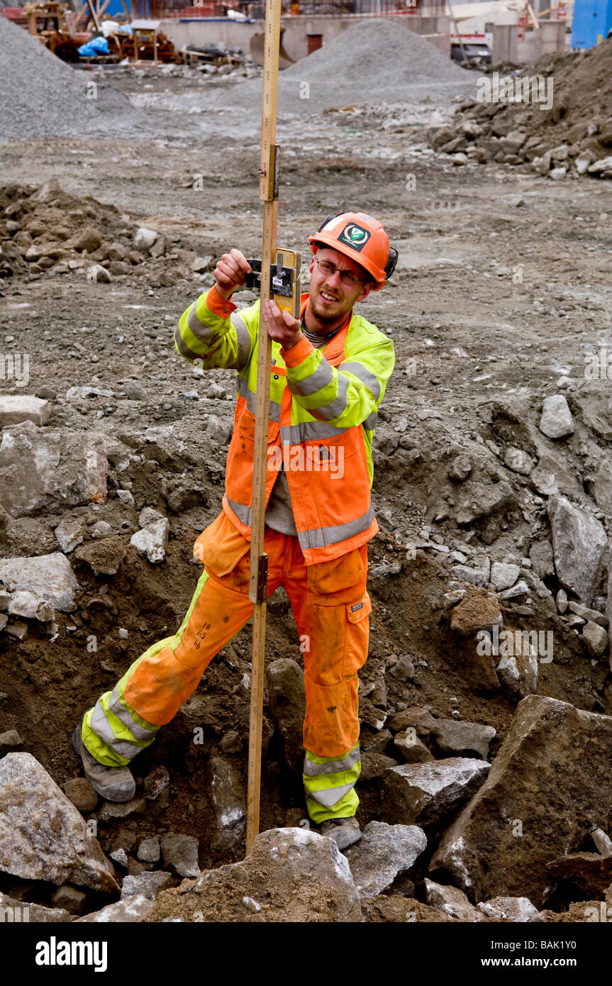 Construction worker marks out an area on a building site to be measured ...
