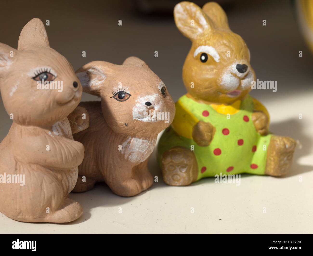 three easter bunnies sitting on a table Stock Photo - Alamy