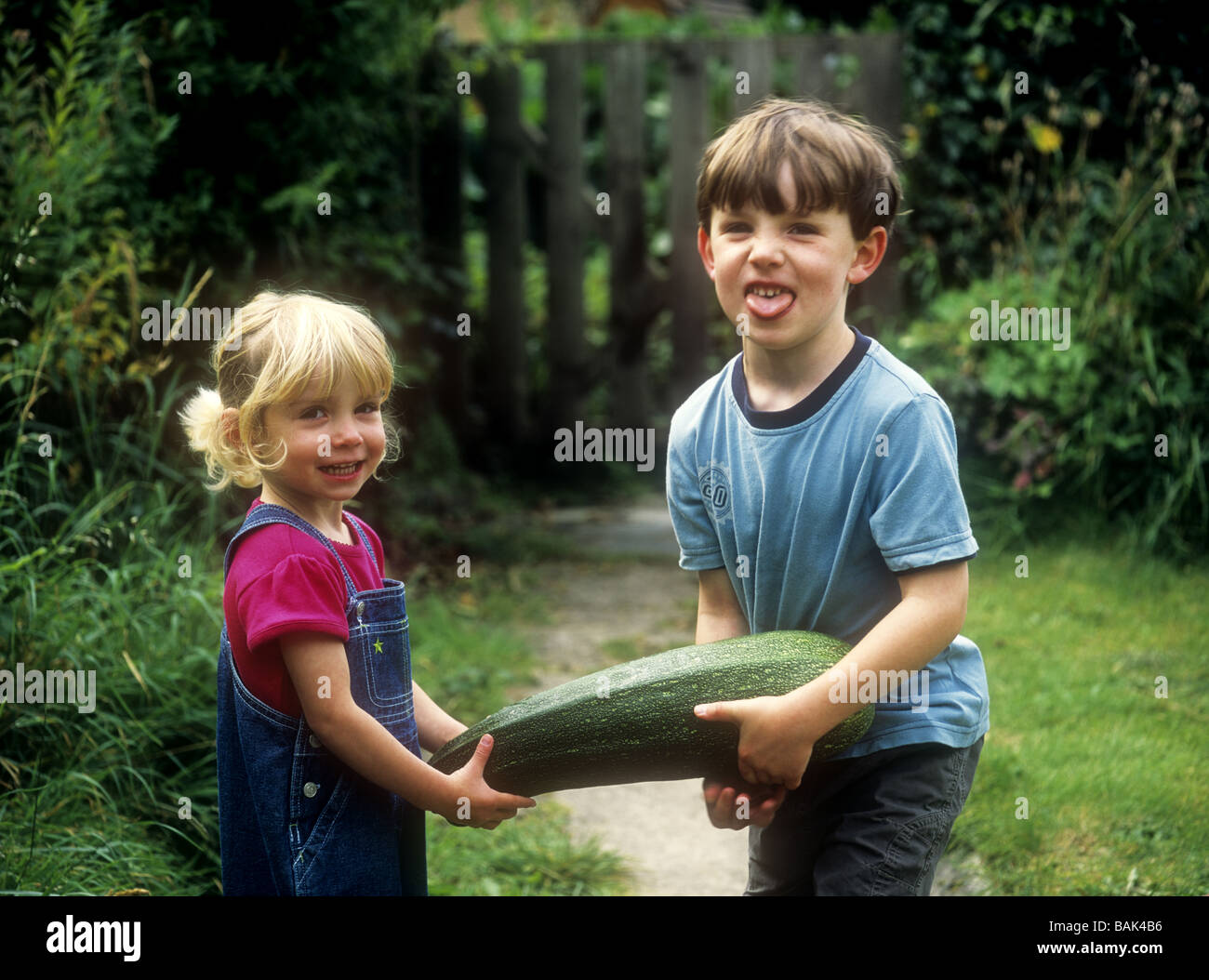 Cheeky young children holding marrow Stock Photo - Alamy