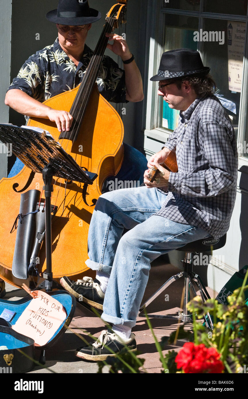 Two musicians play music at city street fair Stock Photo - Alamy