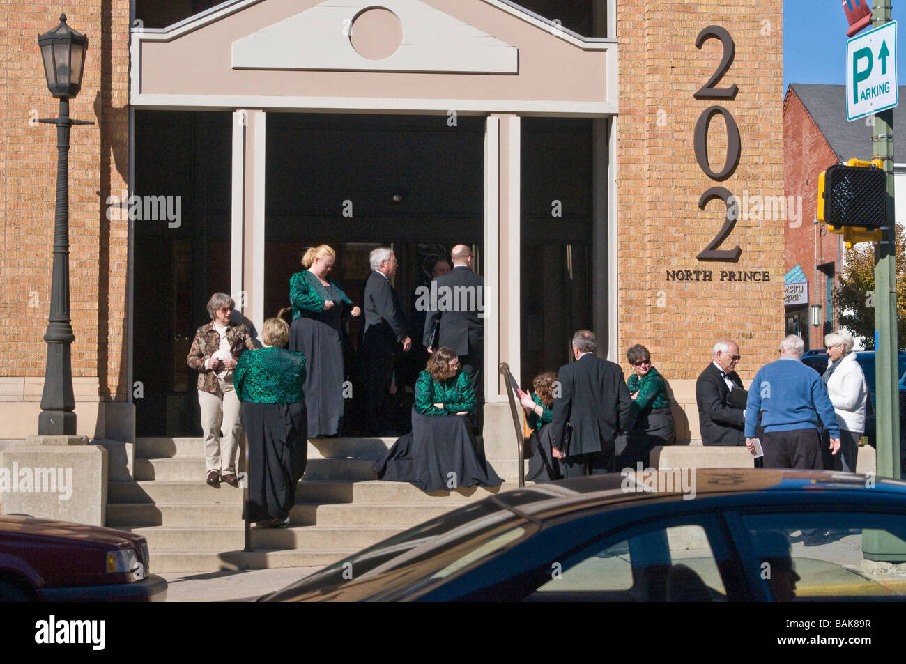 Group congregates outside building Stock Photo - Alamy