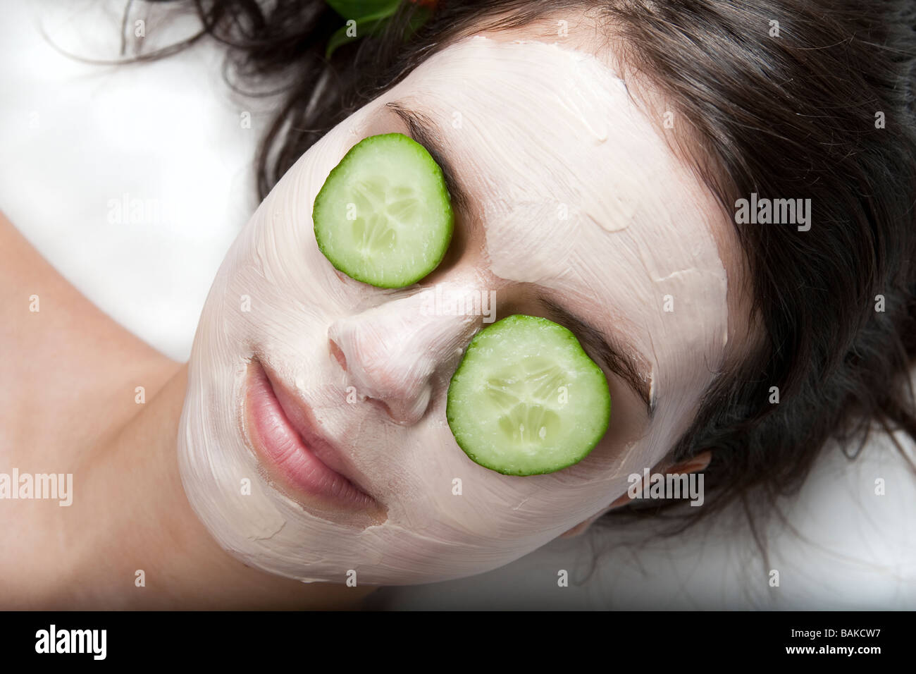 Young woman getting a facial treatment with cucumbers on her eyes at a spa Stock Photo - Alamy