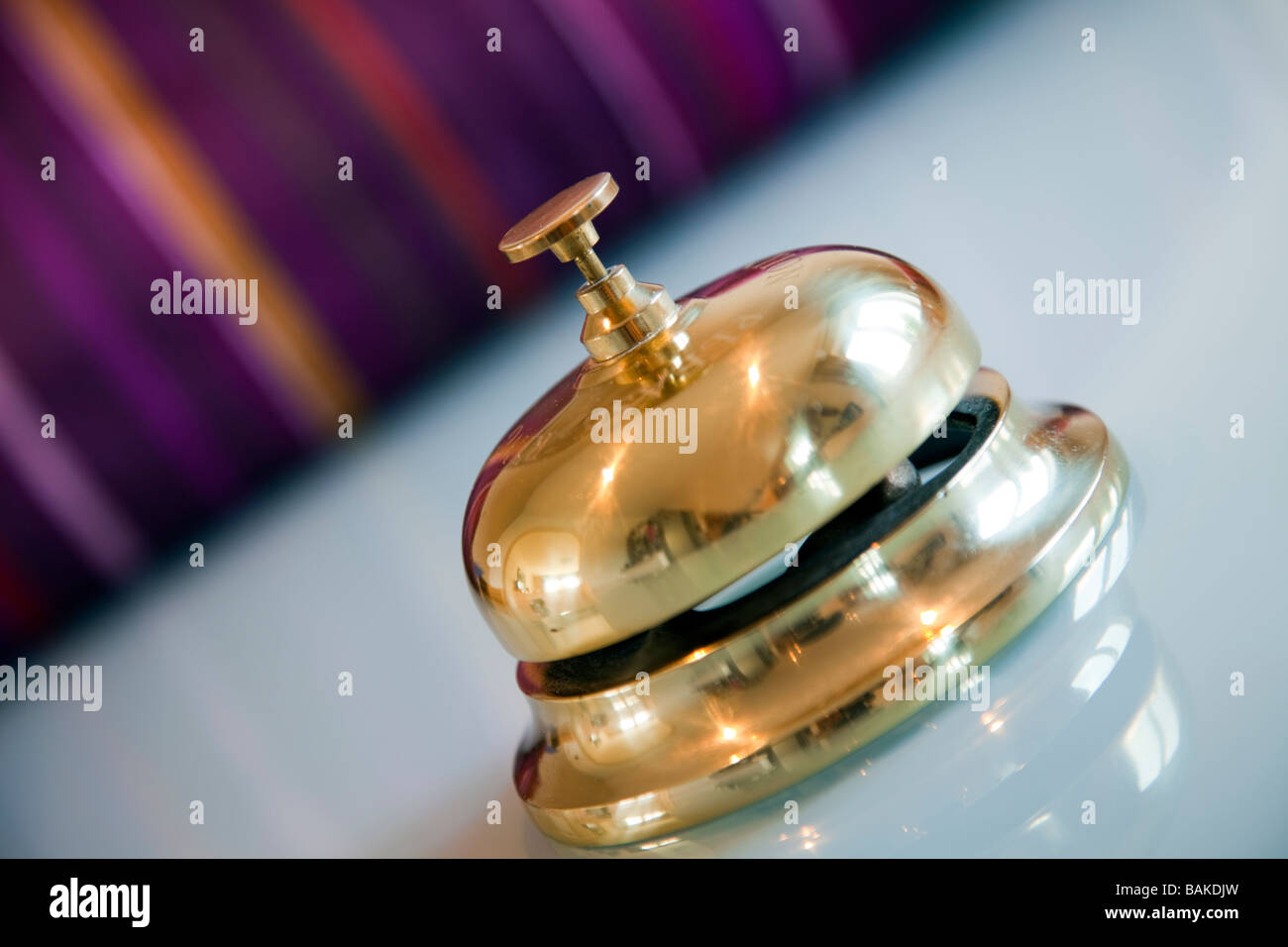 A brass metal concierge bell or reception service bell on a clear clean ...