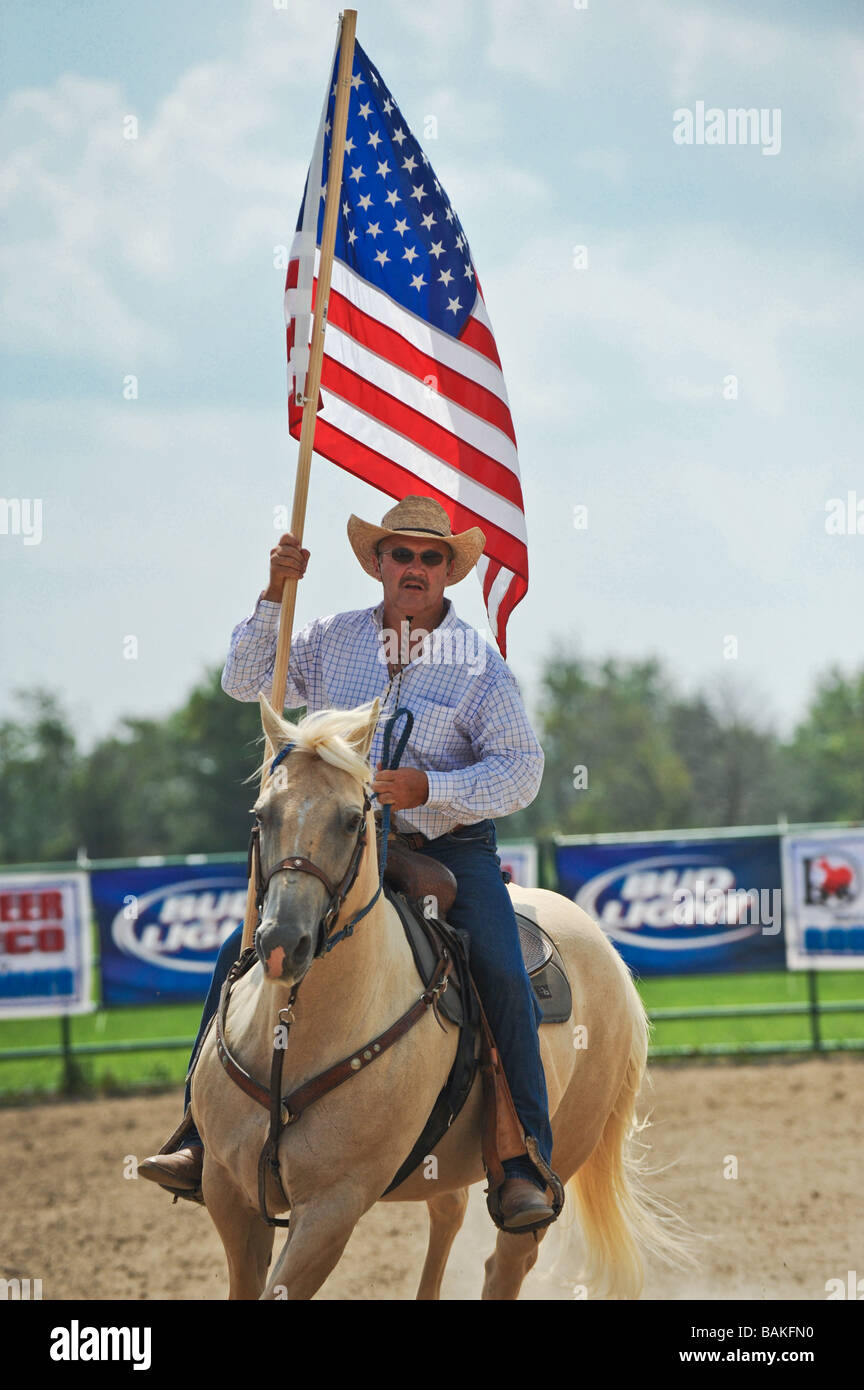 Man displaying American flag during ceremony at rodeo event Stock Photo ...