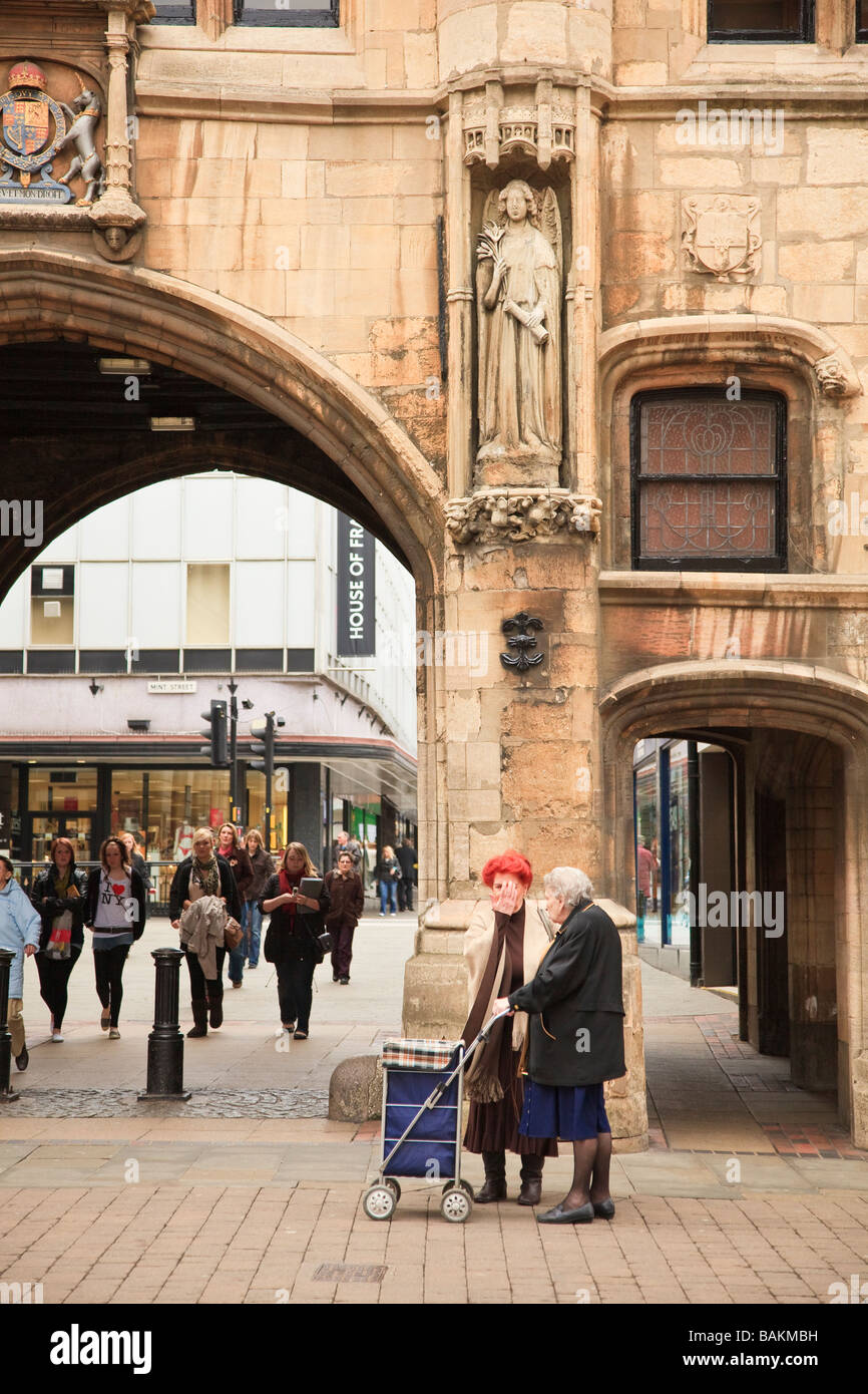 Two Women stand and talk under a statue on the Stonebow and Guildhall ...