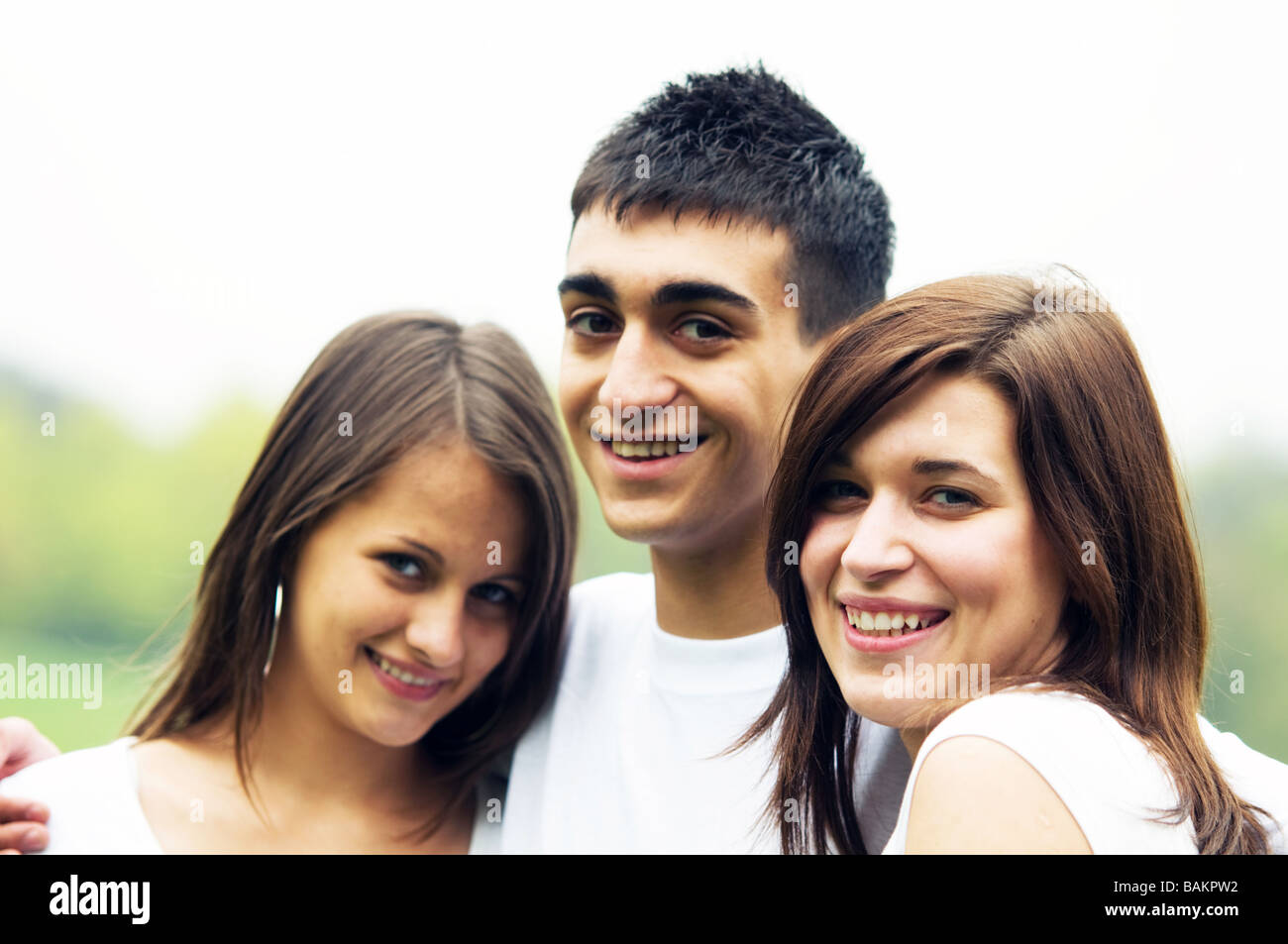 Three young happy friends standing together and smiling Stock Photo - Alamy