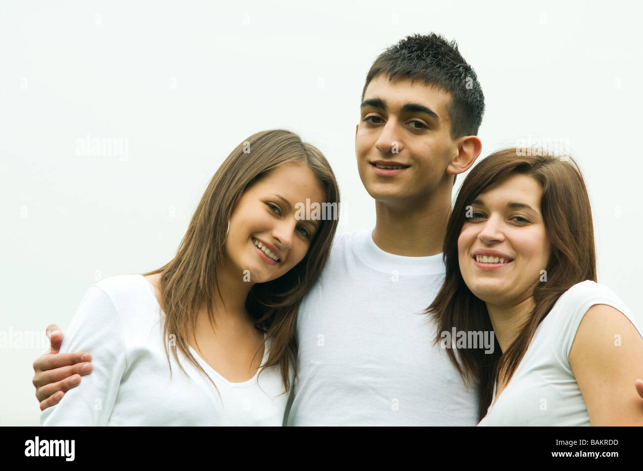 Three young happy friends standing together and smiling Stock Photo - Alamy