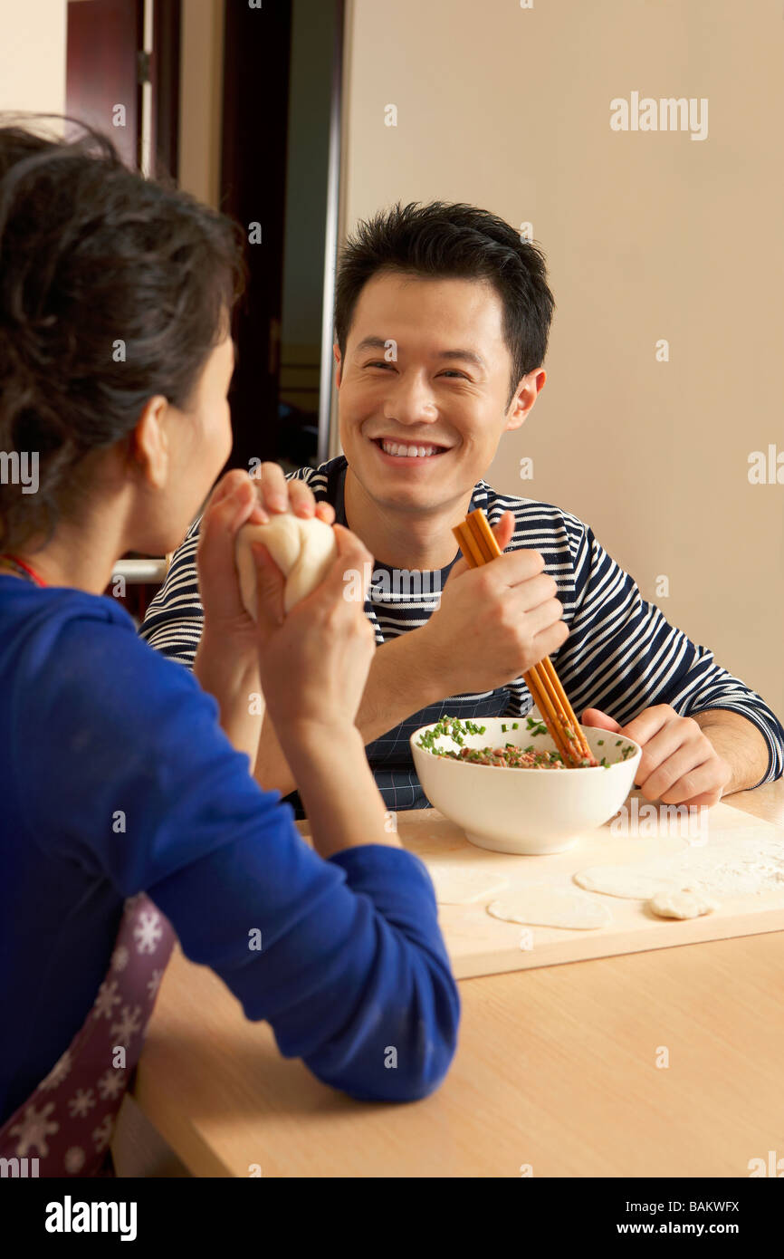 Couple Sitting And Cooking Together Stock Photo - Alamy