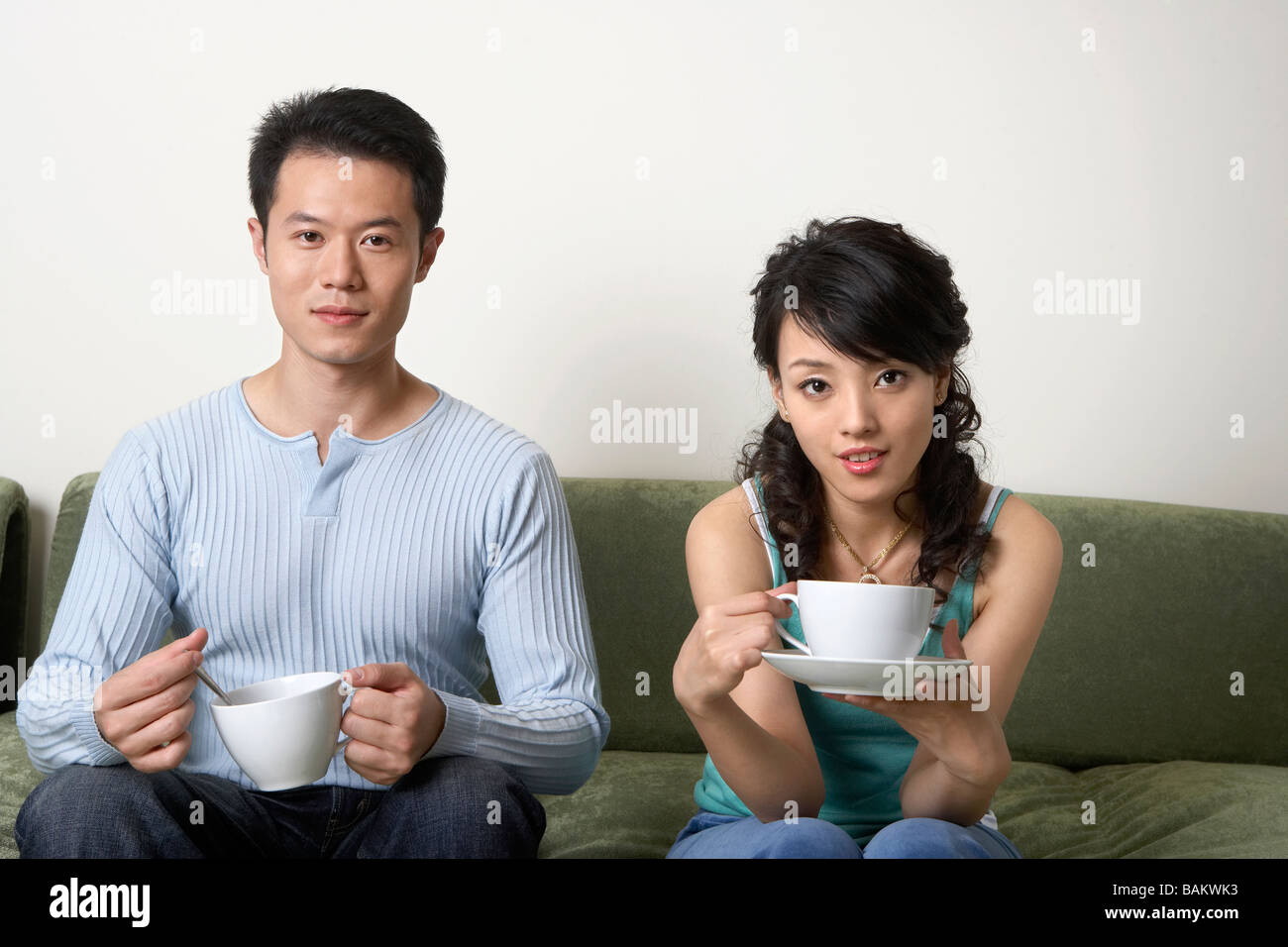 Young People Sitting On Couch, Drinking Tea Stock Photo - Alamy