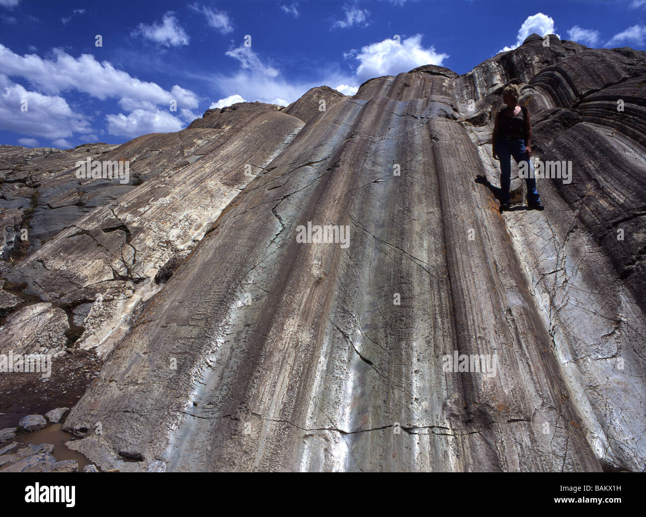 Woman standing on the natural rock slides at the Sacsayhuaman Inca ...