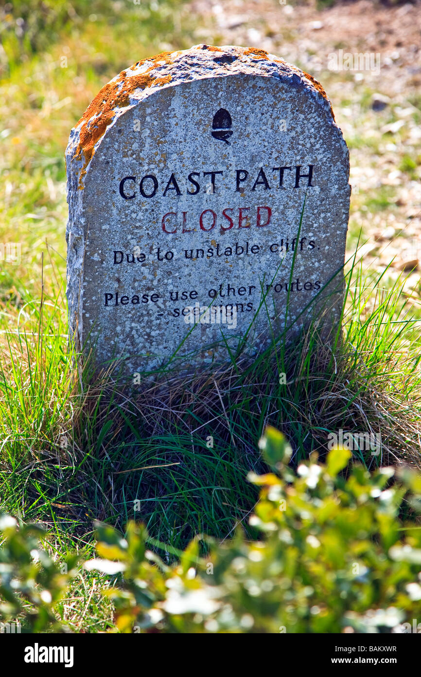 A coastal footpath stone telling walkers that the path is closed due to ...