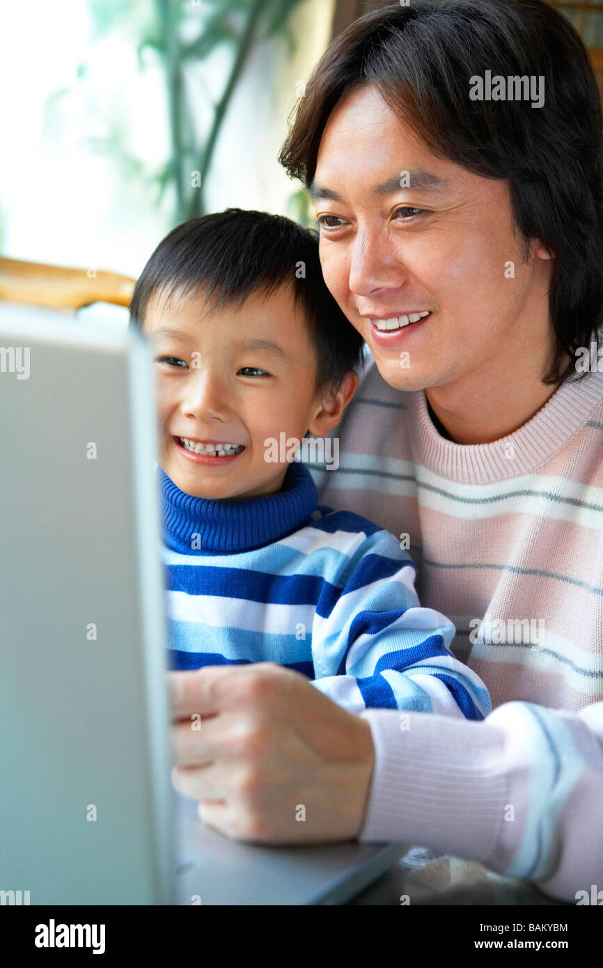 Smiling father son using laptops hi-res stock photography and images ...