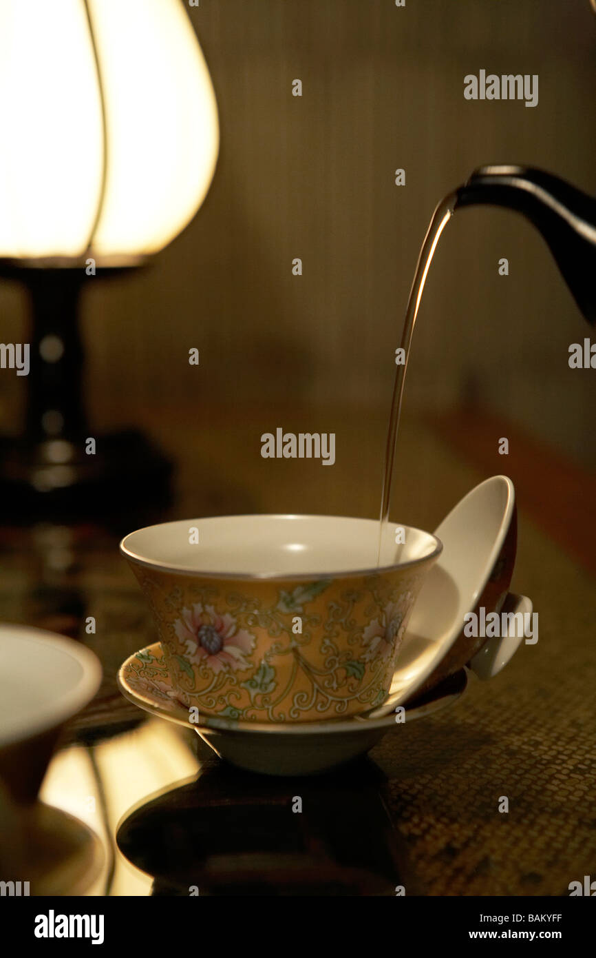 Teapot Pouring Tea Into Tea Cup Stock Photo - Alamy