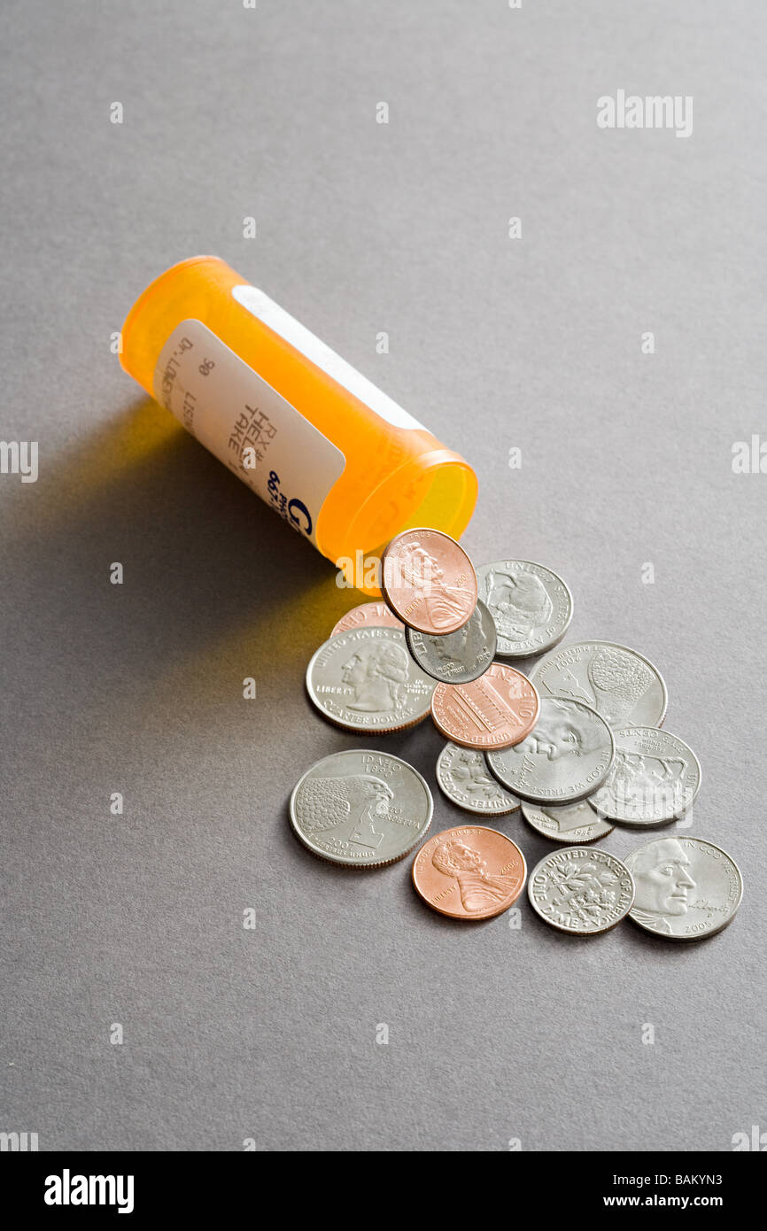 Coins spilling from medicine bottle Stock Photo - Alamy