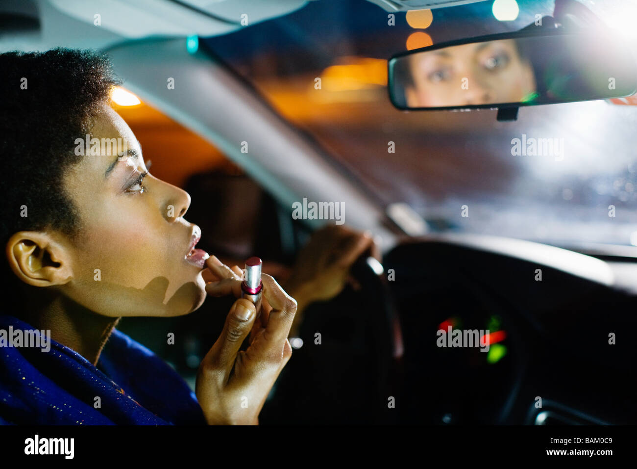 Woman putting on lipstick in car Stock Photo - Alamy