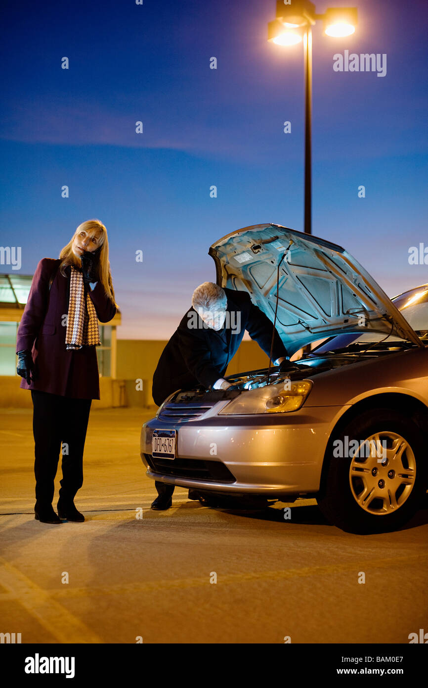Couple with broken down car Stock Photo - Alamy