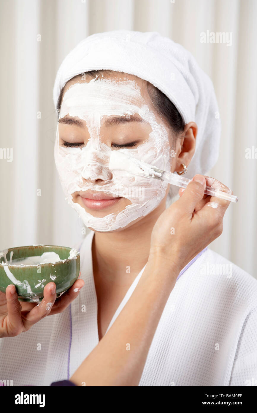 Young Woman Having A Facial Mask Applied Stock Photo - Alamy