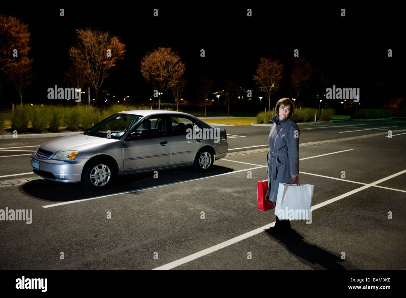 Woman alone in car park Stock Photo - Alamy