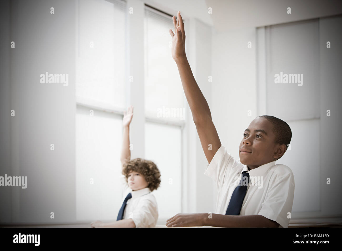 School students with hands raised Stock Photo - Alamy