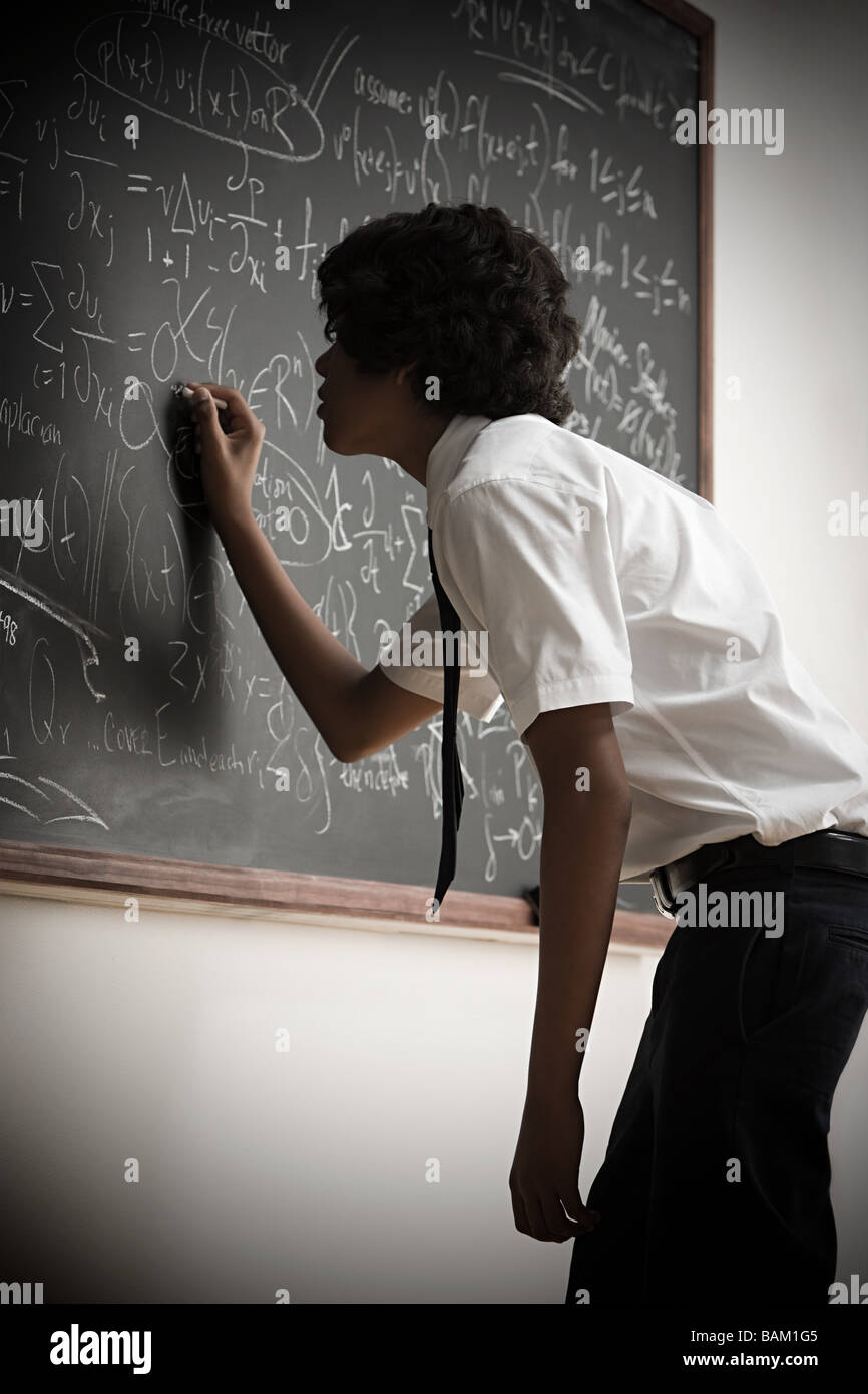 Boy writing on blackboard Stock Photo - Alamy