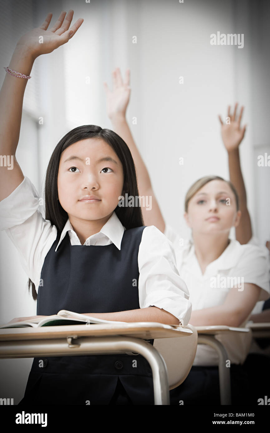 School students with hands raised Stock Photo - Alamy