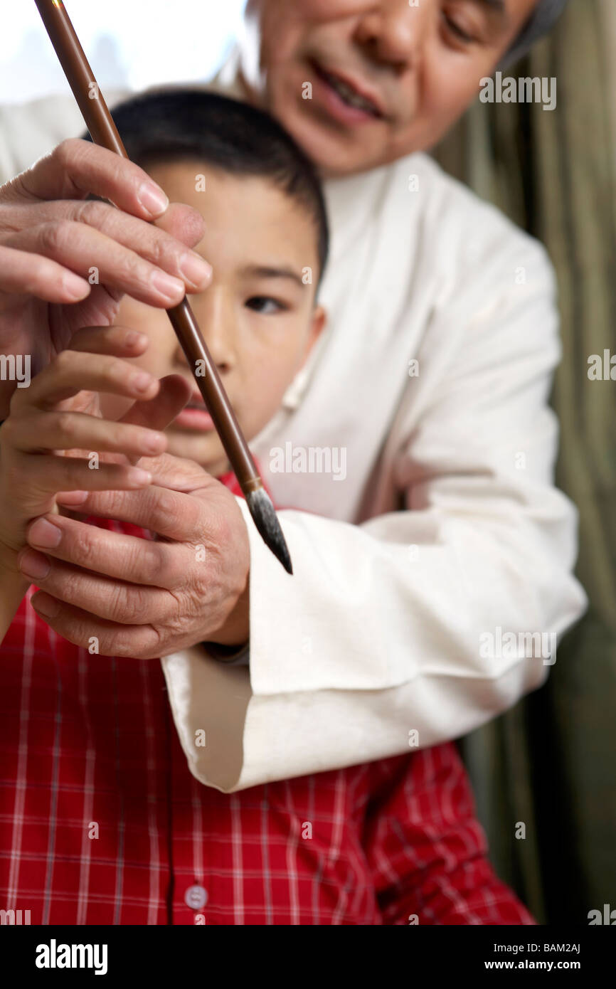Man Teaching His Grandson The Art Of Calligraphy Stock Photo - Alamy