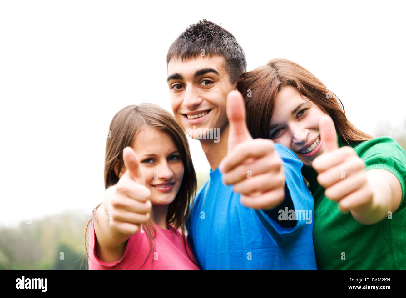 Three young happy friends laughing and giving okay sign Stock Photo - Alamy