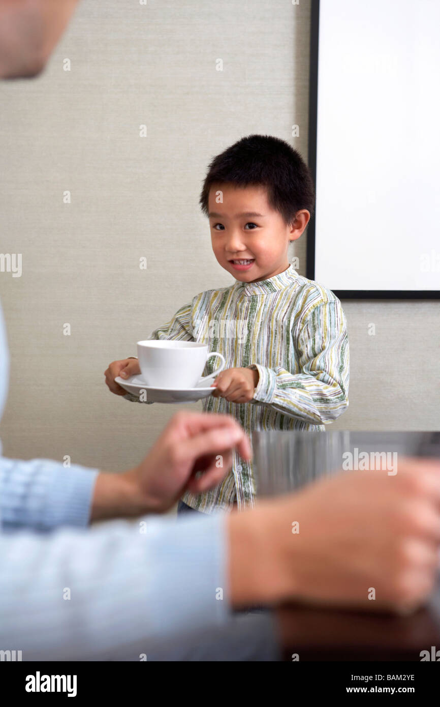 Boy Carrying Cup Of Tea Stock Photo - Alamy