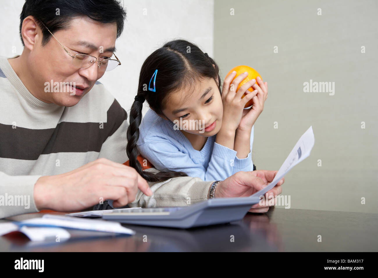 Father And Daughter Looking At Paperwork Together Stock Photo - Alamy