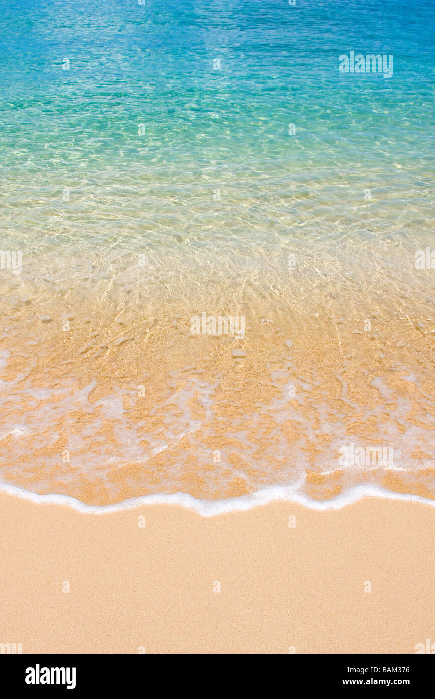 Close-up of Caribbean seashore, showing clear sea gently lapping up ...