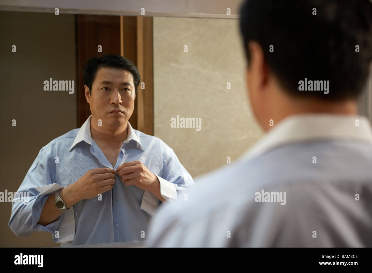 Man Buttoning Up His Shirt Stock Photo - Alamy