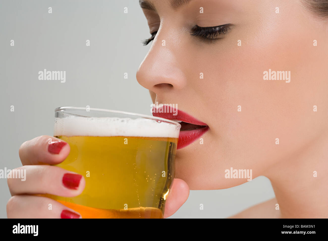 Woman drinking a pint of lager Stock Photo - Alamy