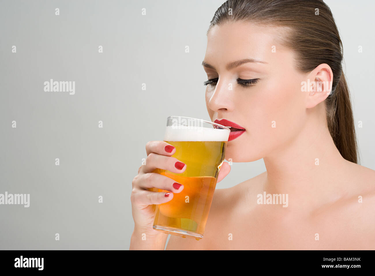Woman drinking a pint of lager Stock Photo - Alamy