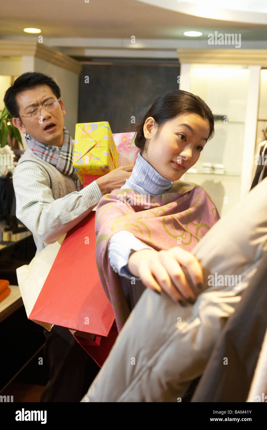 Woman Looking At Clothes, Man Looking Frustrated Stock Photo - Alamy