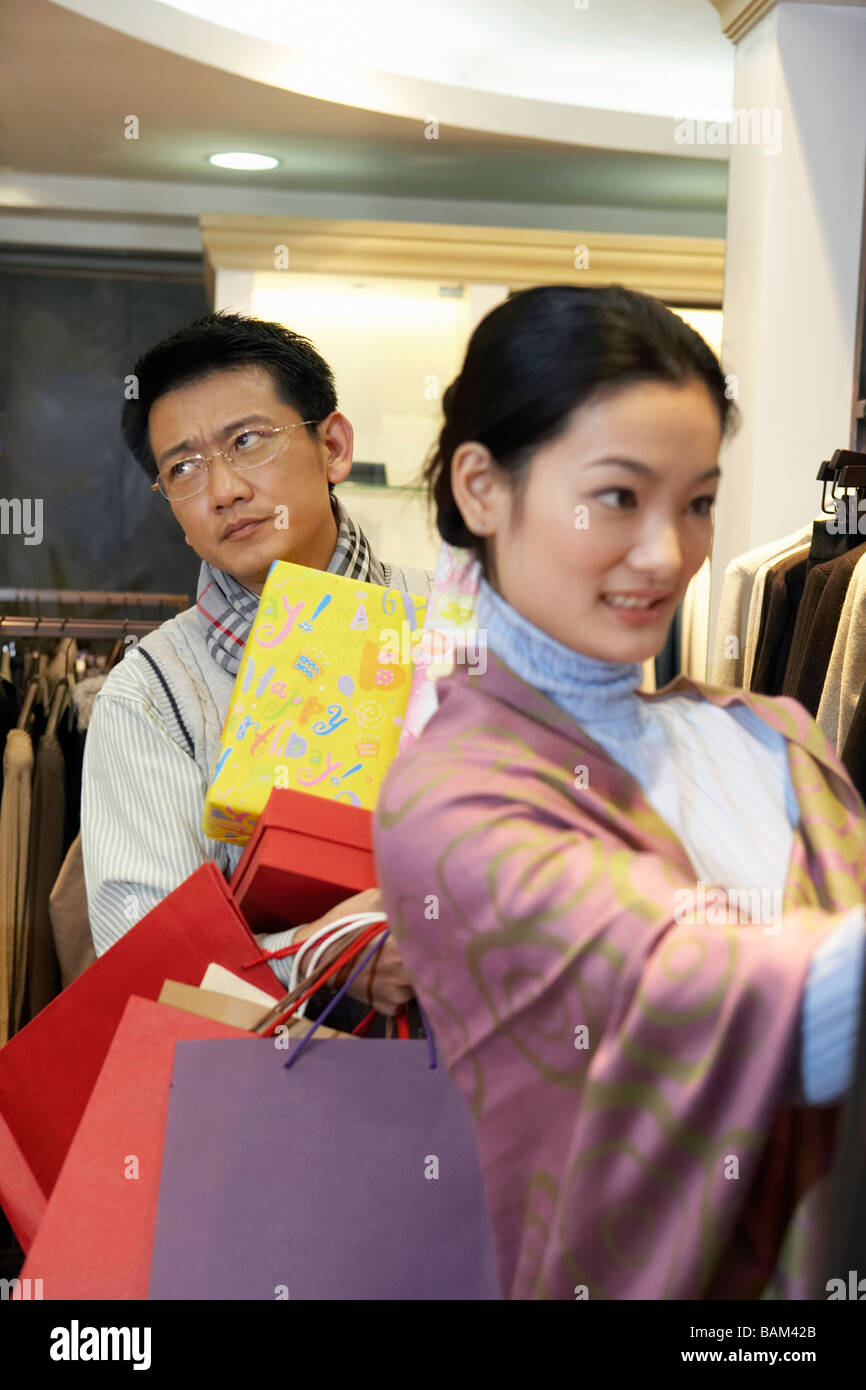 Woman Looking At Clothes, Man Looking Frustrated Stock Photo - Alamy