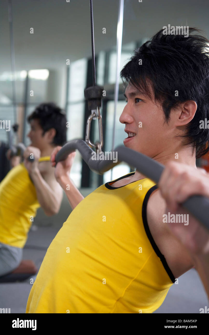 Young Man On An Exercise Machine At The Gym Stock Photo - Alamy